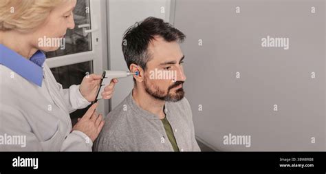 Experienced Audiologist With Tympanometer Probe Doing Tympanometry Procedure And Impedance