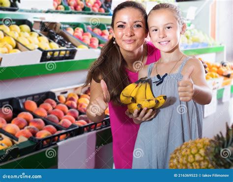 Mujer Con Chica Que Se Ve Satisfecha Y Que Sostiene Los Pulgares Hacia Arriba Imagen De Archivo