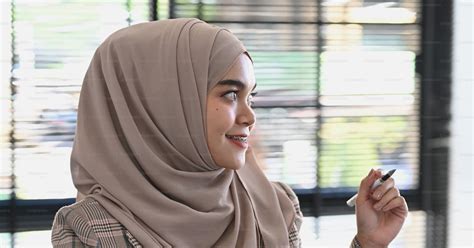 사무실에 서 있는 동안 문서 파일과 펜을 들고 있는 아바야의 쾌활한 무슬림 젊은 여성의 초상화 사진 Unsplash의 태국 이미지