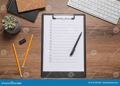 Clipboard With Checkboxes Computer Keyboard And Plant On Wooden Table