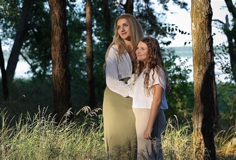 Premium Photo Sisters In The Forest Stand And Look At The Sun