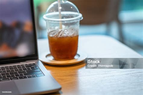 카페의 커피숍에 있는 나무 책상 사무실 책상에 키보드 노트북 컴퓨터가 있는 컵 머그잔에 아이스 커피의 클로즈업 비즈니스 작업 개념 중 0명에 대한 스톡 사진 및 기타 이미지