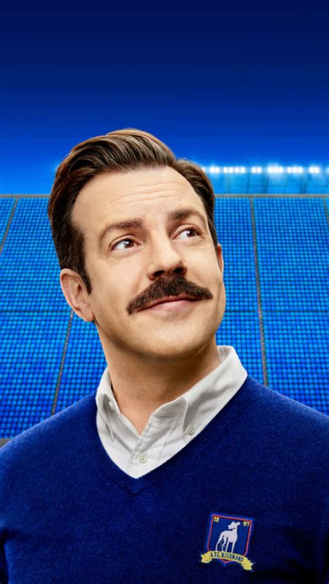 Cheerful Ted Lasso In Vibrant Stadium Wallpaper Background Free Download