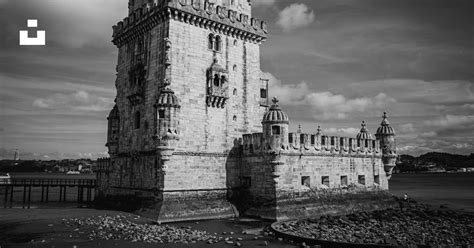 Foto Un Castillo En Una Orilla Rocosa Con La Torre De Belém Al Fondo Imagen Lisboa Gratis En