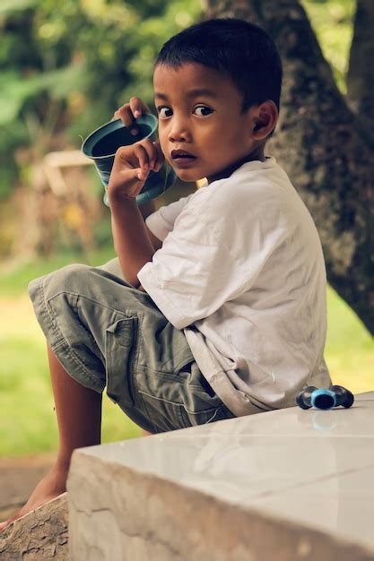 Premium Photo Portrait Of Boy Sitting On Terrace