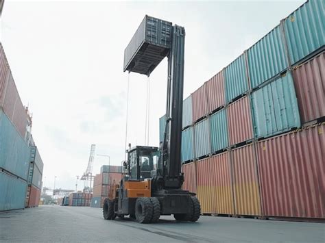 A Reach Stacker Lifting And Stacking Shipping Containers At A Container