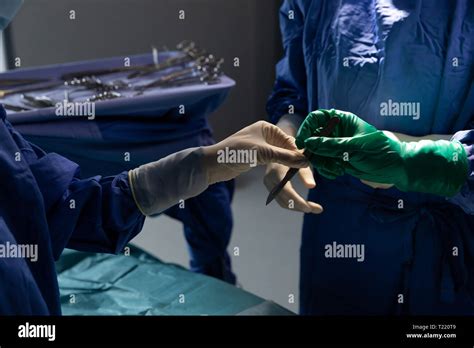 Surgeons Holding Surgical Knife In Operating Room During Surgery Stock