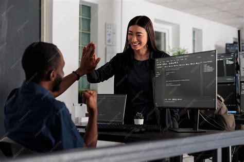 Premium Photo Happy System Engineers Celebrating Successful Code