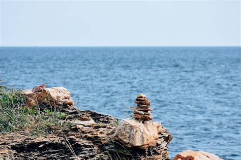 Premium Photo Stack Of Rocks By Sea Against Clear Sky