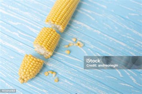 La Mazorca De Maíz Con Hojas Verdes Se Encuentra Sobre El Fondo De Color Azul Mesa Foto De Stock