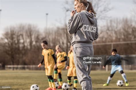 Young Blonde Female Soccer Coach And Her Girl Football Team High Res