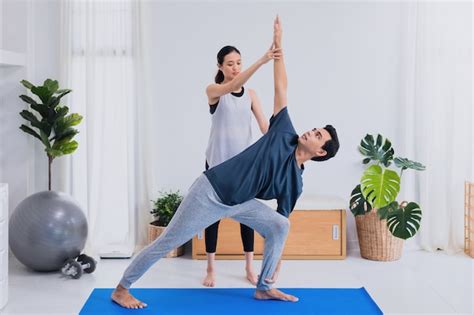 Premium Photo Asian Young Couple Exercise And Play Yoga Together At Home