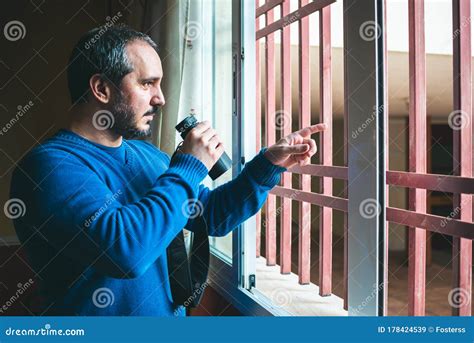 Man Watching The Neighbors Through The Window During Quarantine Stock