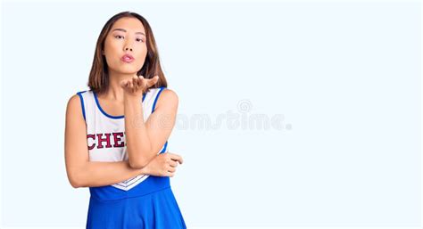 Young Beautiful Chinese Girl Wearing Cheerleader Uniform Looking At The