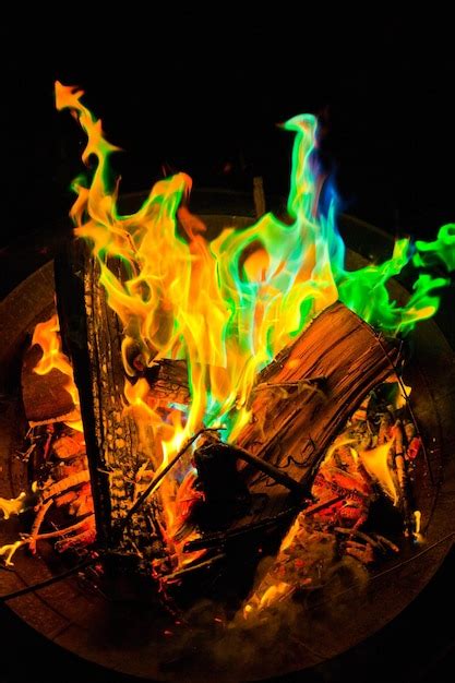 Premium Photo Vibrant Fire Pit Display With Green And Blue Flames In Outdoor Setting