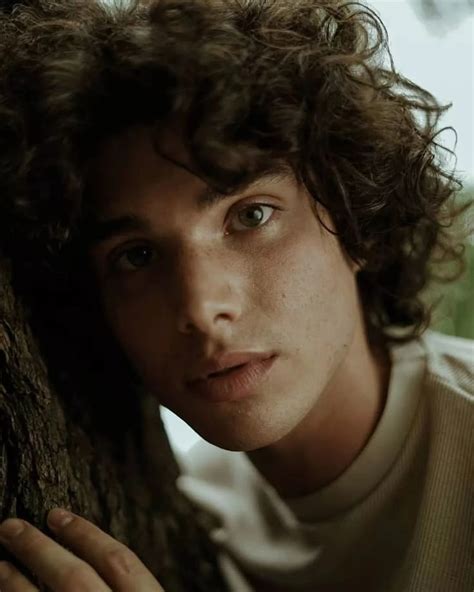 A Close Up Of A Person Leaning On A Tree With His Hand On The Trunk