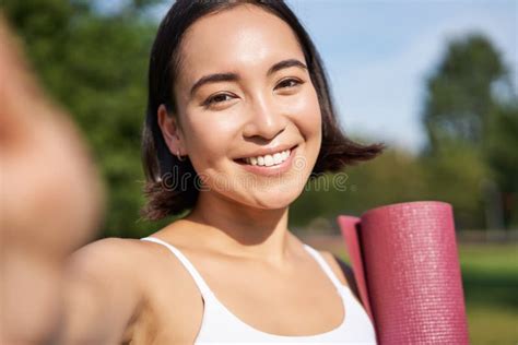 Happy Asian Fitness Girl Takes Selfie With Rubber Yoga Mat In Park
