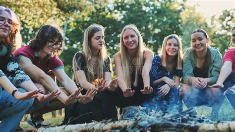 Group Of Young Students Enjoying A Summer Camp Warming Their Hands By