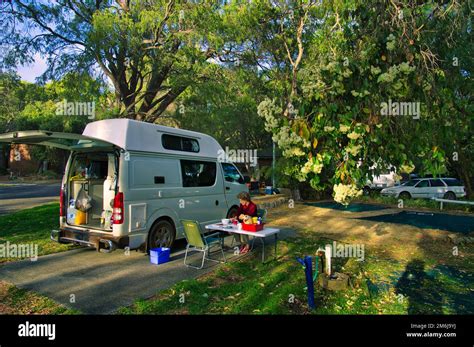 Middle Aged Woman Sitting Beside A Small Rv On A Camping With Mature