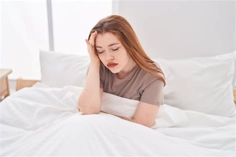 Premium Photo Young Redhead Woman Stressed Sitting On Bed At Bedroom