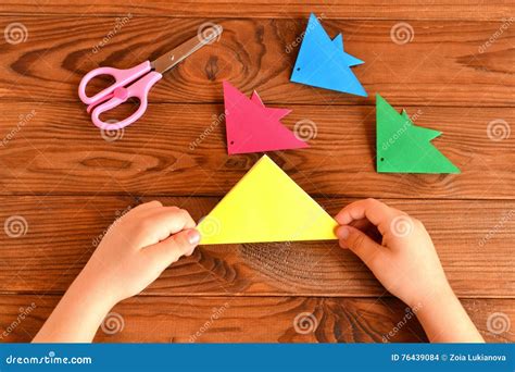 Origami Färgrik Fisk Sax Arket För Barnhållpapper I Hans Händer Och Danandeorigamin Fiskar