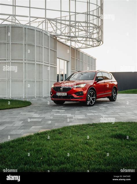 Red Seat Tarraco Parked Near Modern White Building Front Three Quarter