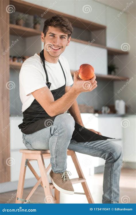 Hombre Atractivo Con Una Manzana Sentada En La Cocina De Su Casa Imagen