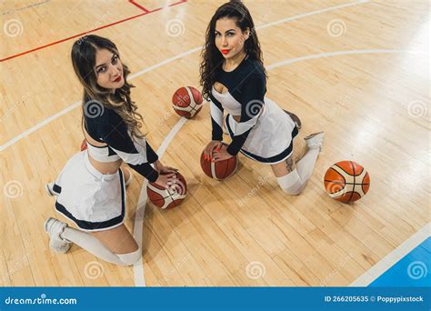 Vibrant Cheerleaders Dressed In Mini Skirts With Basketballs On An
