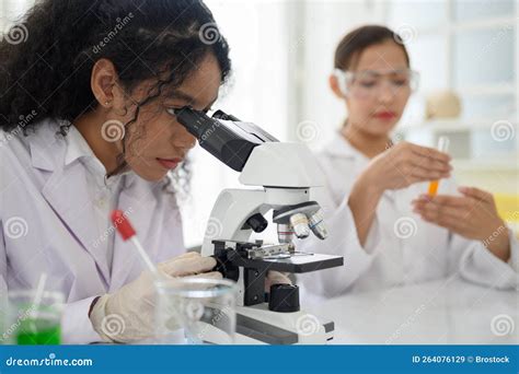 Portrait Of Beautiful Black Scientist Looking Under Microscope Stock