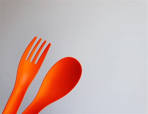 Premium Photo Plastic Fork And Spoon In Orange Color
