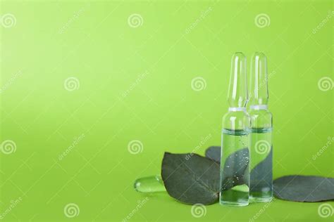 Pharmaceutical Ampoules With Medication And Eucalyptus Leaves On Green