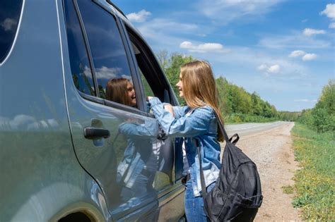 Premium Photo A Young Girl A Teenager With A Backpack Hitchhiker