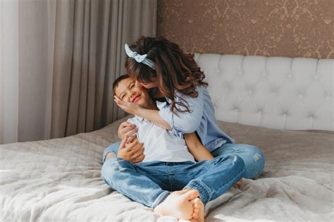 Maman Et Son Fils Sont Assis Sur Le Lit Sembrassent Et Samusent