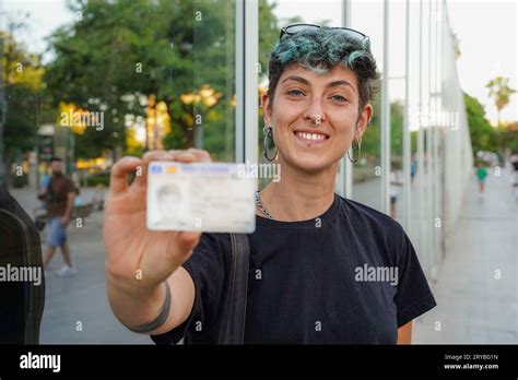 smiling non binary gender showing their id identity document in lgbt