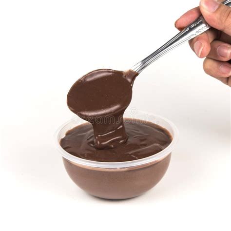Creamy Chocolate Pudding Is Being Scooped From A Small Plastic