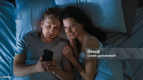 Happy Young Pareja Utilizan Smartphone En La Cama En La Noche Comparten