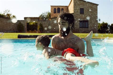 Father Teaching Boy To Swim In Pool By Stocksy Contributor Guille