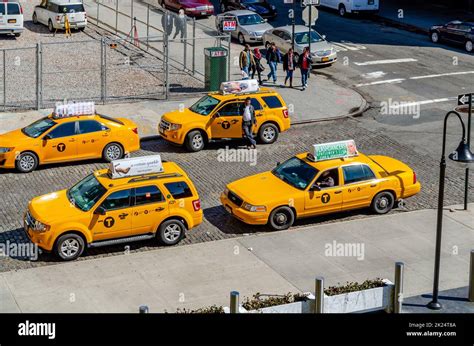 Different Car Models Of Yellow Taxi Cabs Parked In Side Street In