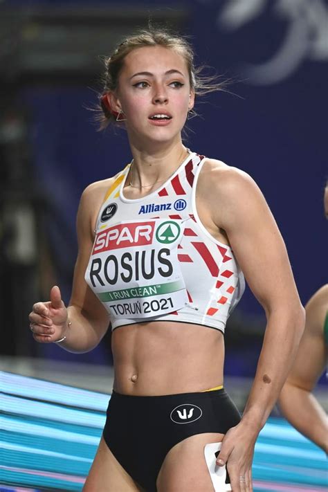A Woman Is Running On The Track In A Bra Top And Black Shorts With Her