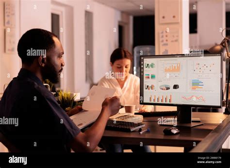 Analyst Comparing Marketing Report On Computer And Clipboard Employee