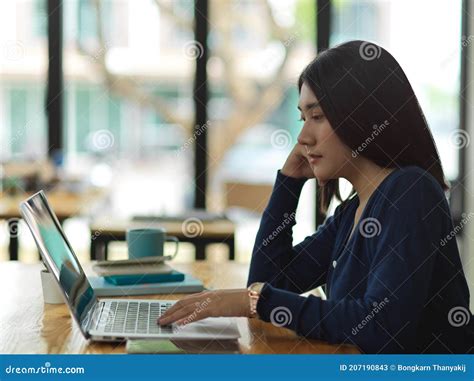 Female University Student Doing Assignment With Laptop In Library Stock