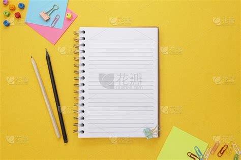 回到学校的概念。打开空笔记本，学习用品，便利贴。黄色背景。平躺，俯视图。