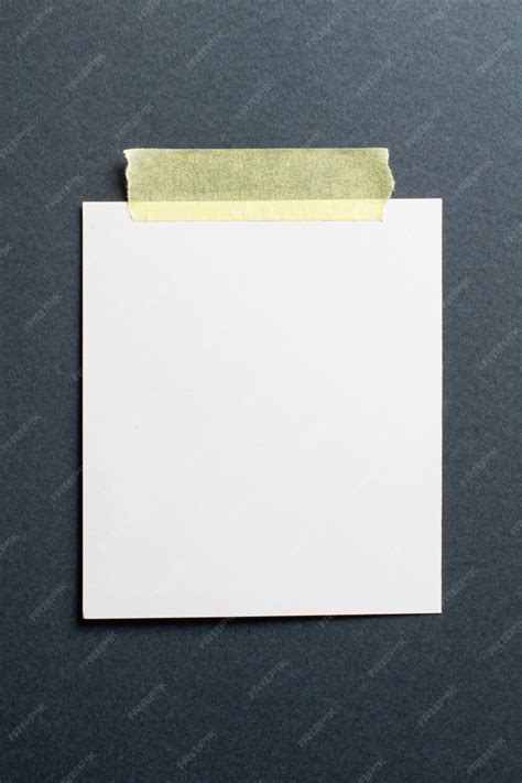 부드러운 그림자와 검은 공예 종이 배경에 노란색 스카치 테이프 빈 폴라로이드 사진 프레임 무료 사진