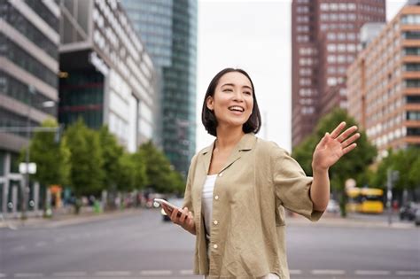 Free Photo Happy Asian Girl Passing By Friend And Waving At Them On
