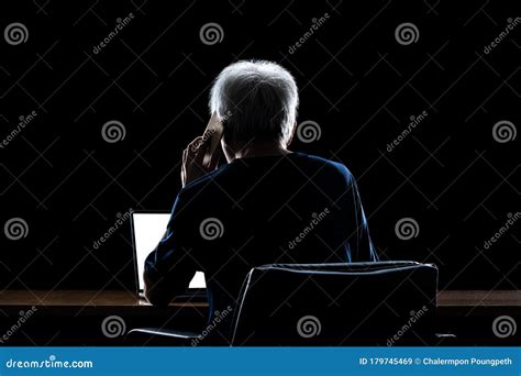 Back View Of A Man With Gray Hair Working From Home Late At Night