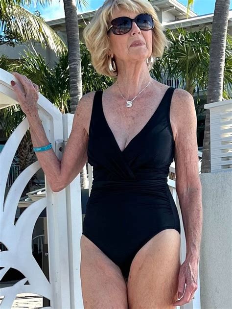 An Older Woman In A Black Swimsuit Posing For The Camera