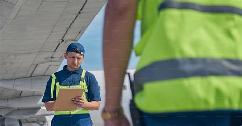 여객기 날개 아래 클립보드에 양식을 작성하는 집중 유지 보수 엔지니어 사진 Unsplash의 사람 이미지