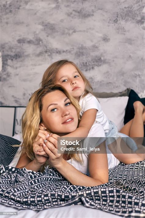 어머니와 그녀의 딸 아이 소녀 재생 및 포옹 사랑스러운 젊은 어머니는 웃고 귀여운 재미있는 아기 딸을 껴안고 집에서 함께 시간을 즐기고 있습니다 가정의 방에 대한 스톡 사진