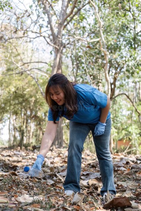 A Cute Young Woman Holds A Garbage Bag And A Group Of Asian Volunteers Collect Garbage In