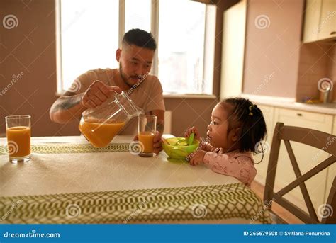 Father Pour Juice from Jar in Cup and Daughter Eat Stock Photo - Image of breakfast, drink ...